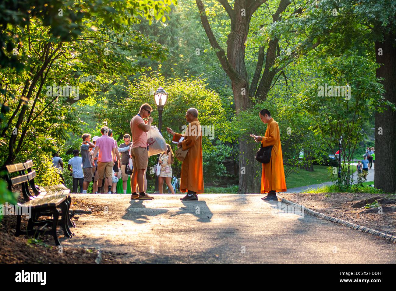 Monks in traditional orange robes engaging with visitors in Central ...
