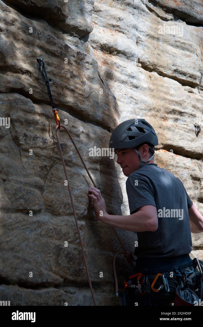 Male climber gripping rock face while finding position Stock Photo - Alamy