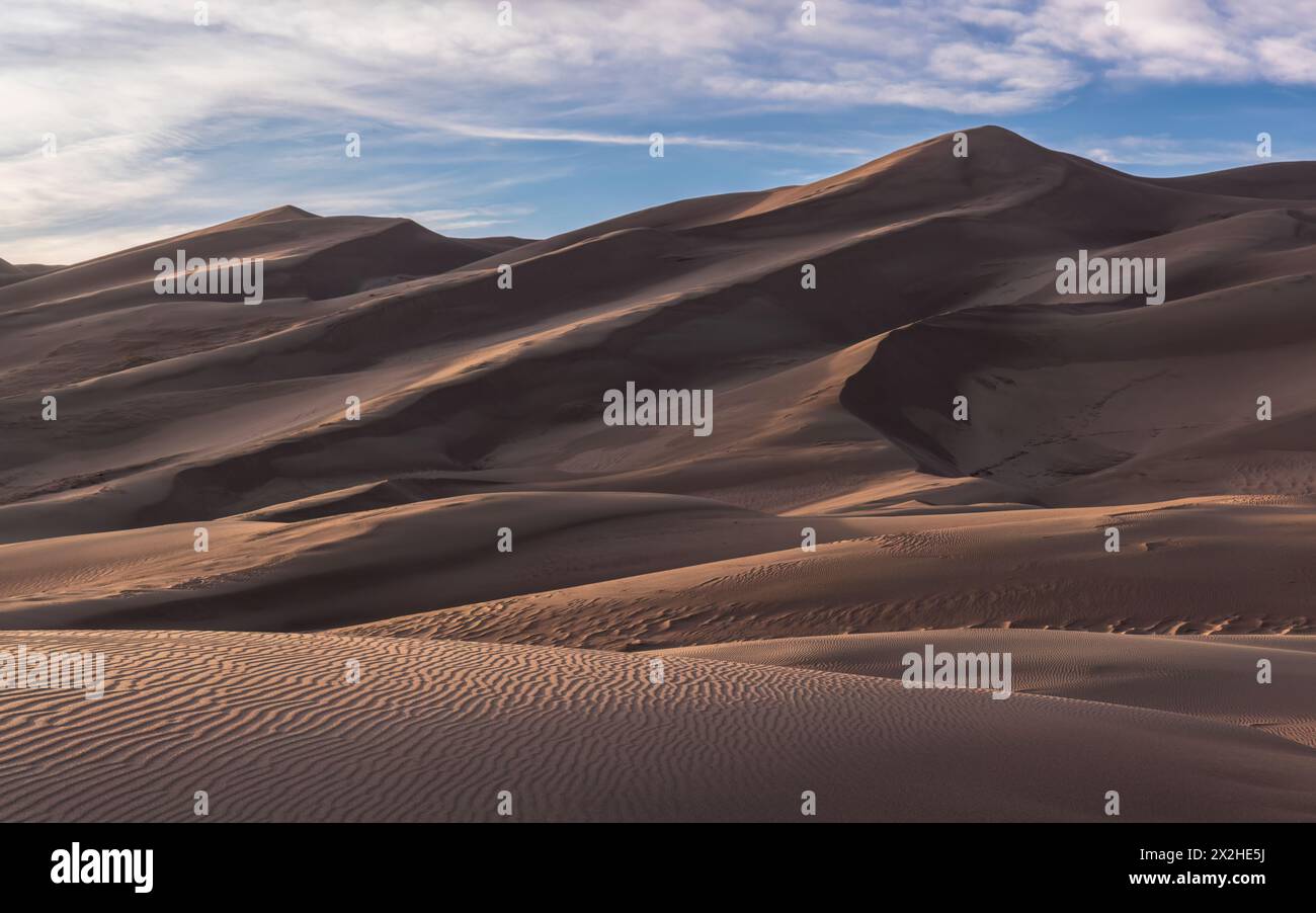 Many layers of wind textured dunes in late afternoon light in Great ...