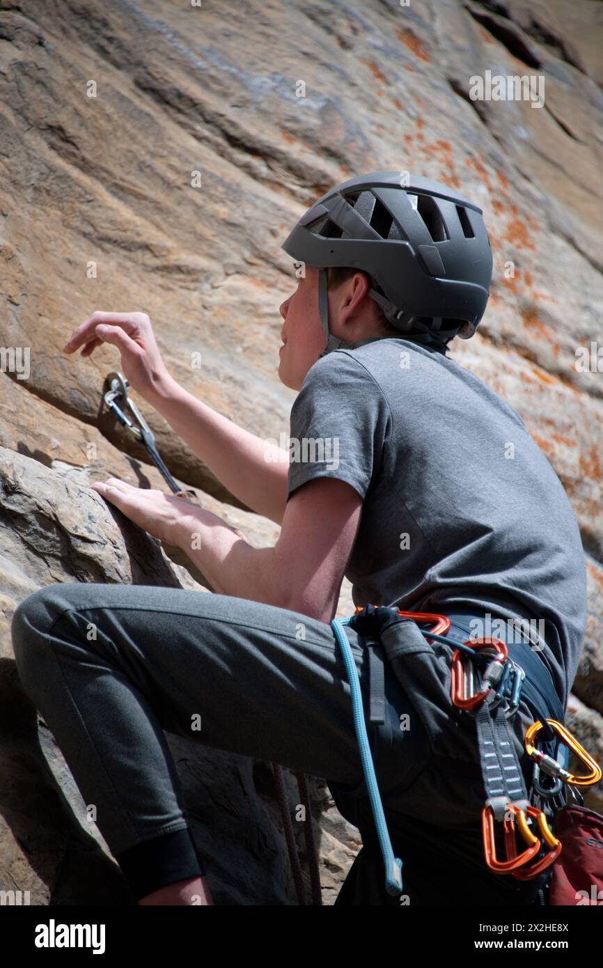 Side view of male climber reaching forward for grip on rock face Stock ...