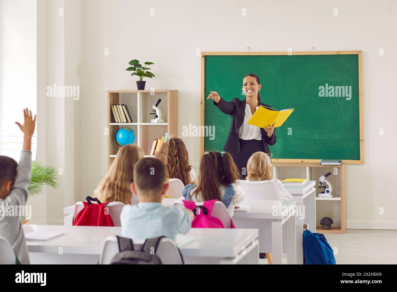 Schoolchildren listening to teacher in classroom during lesson Stock ...