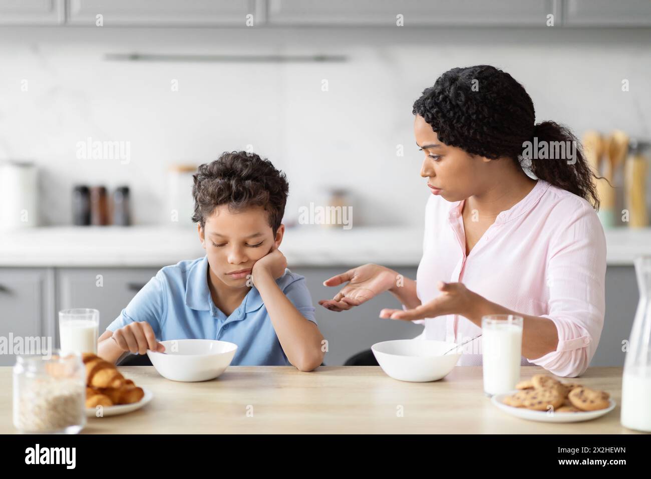 Concerned mother with an uninterested in breakfast boy Stock Photo - Alamy