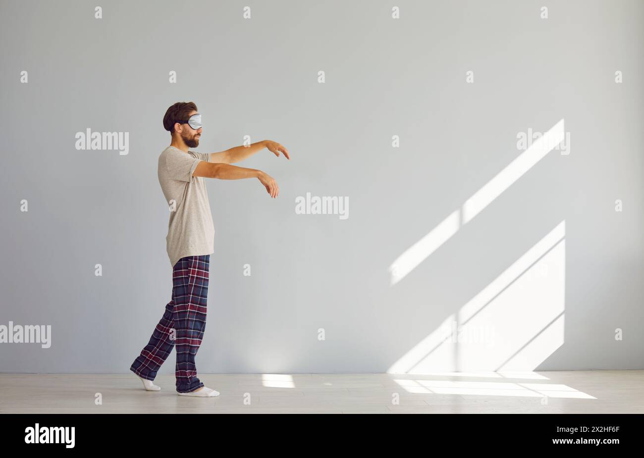 Full length portrait of young sleepwalker man in pajamas suffering from ...