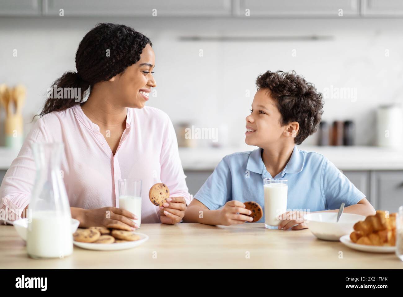 Mother and son sharing a cookie moment Stock Photo - Alamy