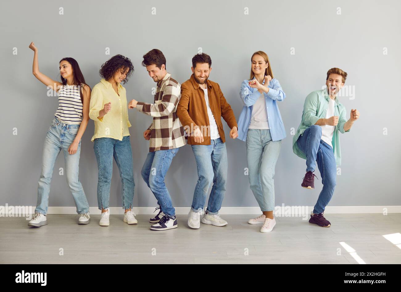 Six carefree cheerful young people dancing and having fun while meeting ...