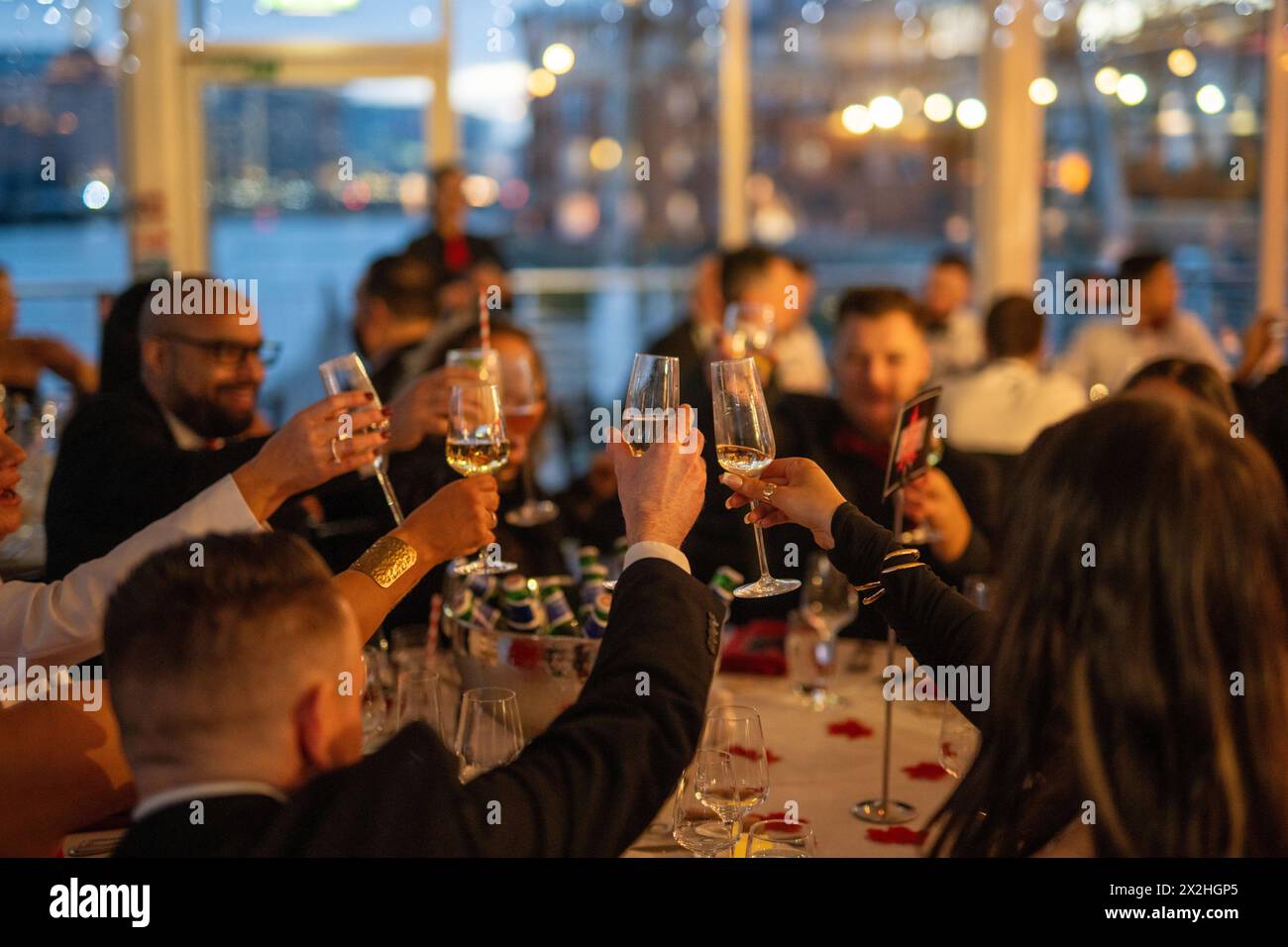 Diners raise a toast at a dinner. Photo date: Saturday, March 23, 2024 ...