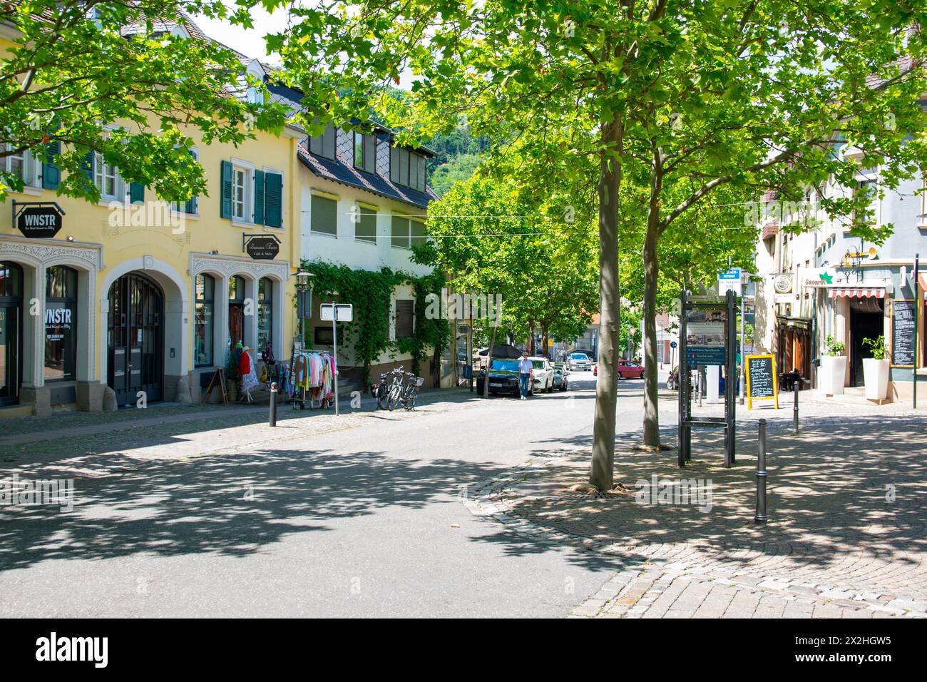 The center of little city in Germany. Street with much trees, shops ...