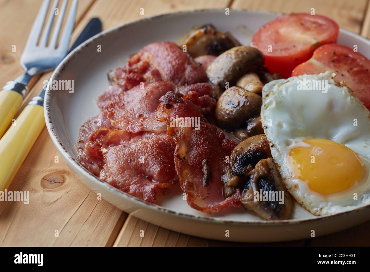 Fried breakfast with bacon,eggs,mushrooms and tomatoes Stock Photo - Alamy