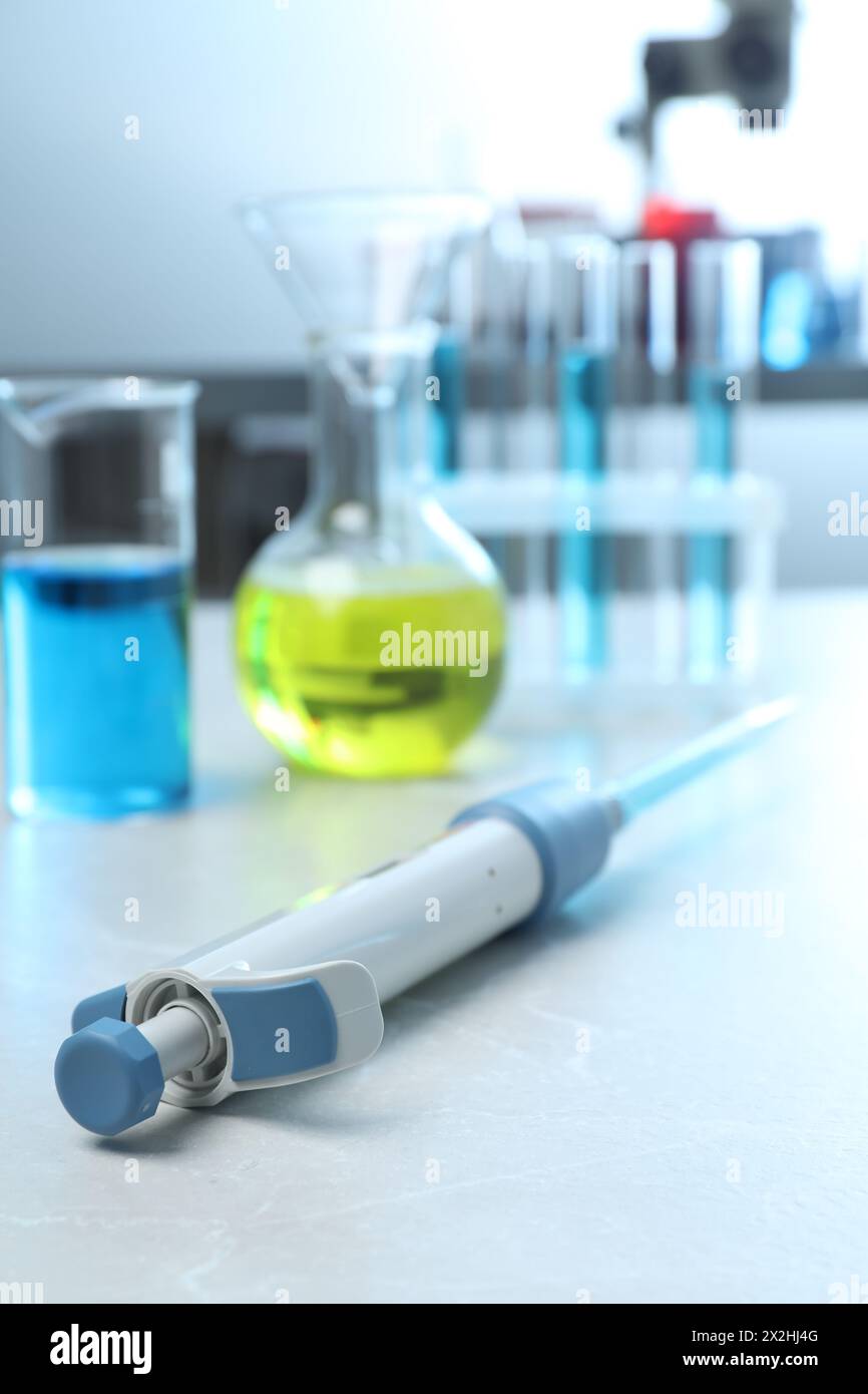 Laboratory analysis. Micropipette and different glassware with liquids ...