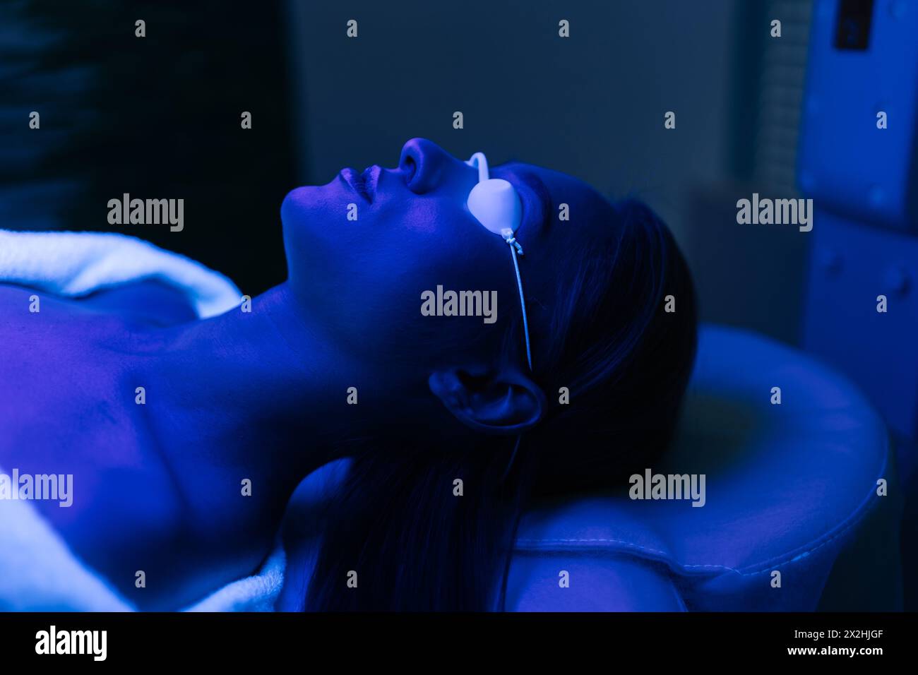 Closeup face of female patient undergoes blue LED light therapy for ...