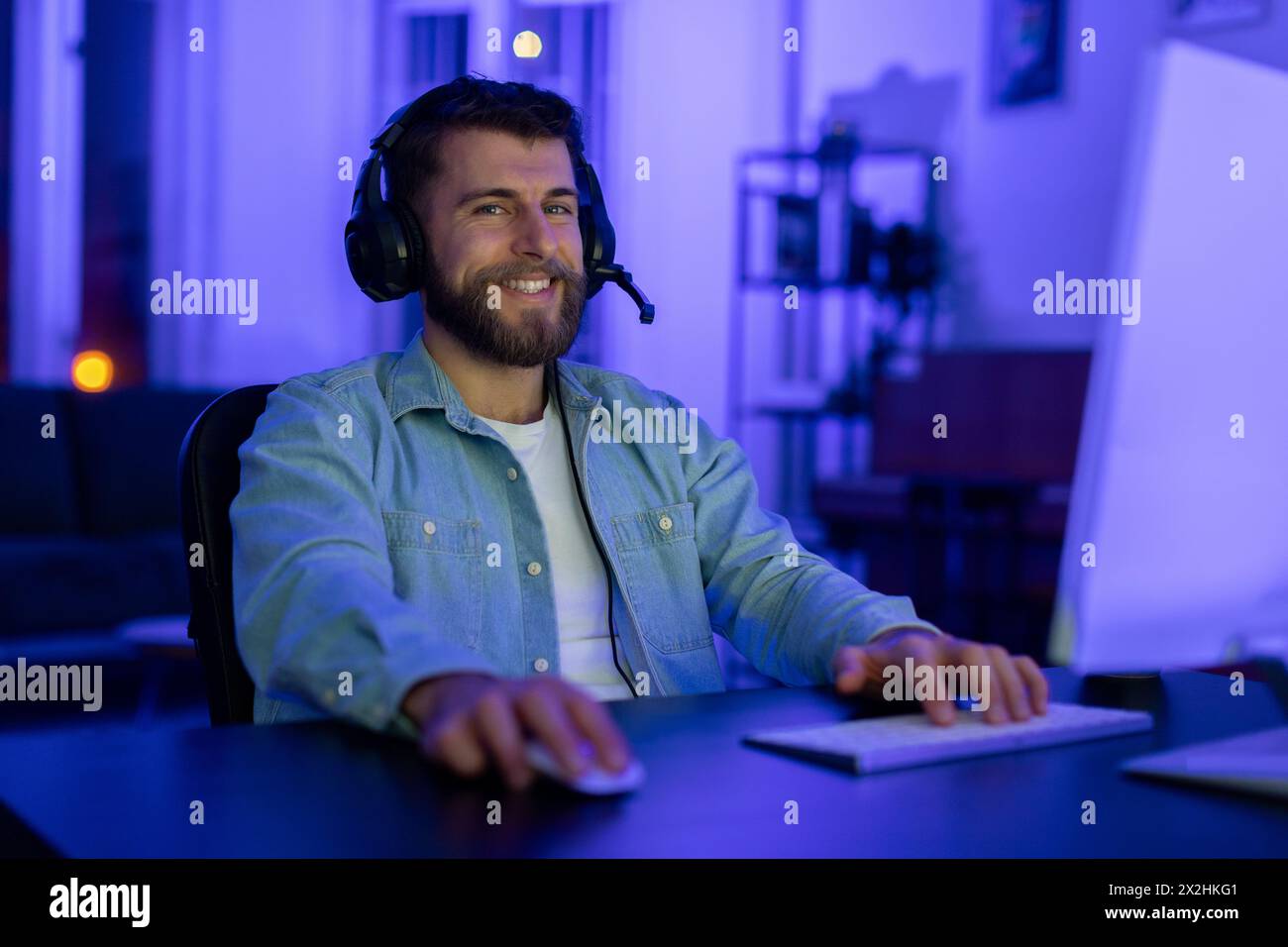 Smiling gamer with a headset and a microphone Stock Photo - Alamy