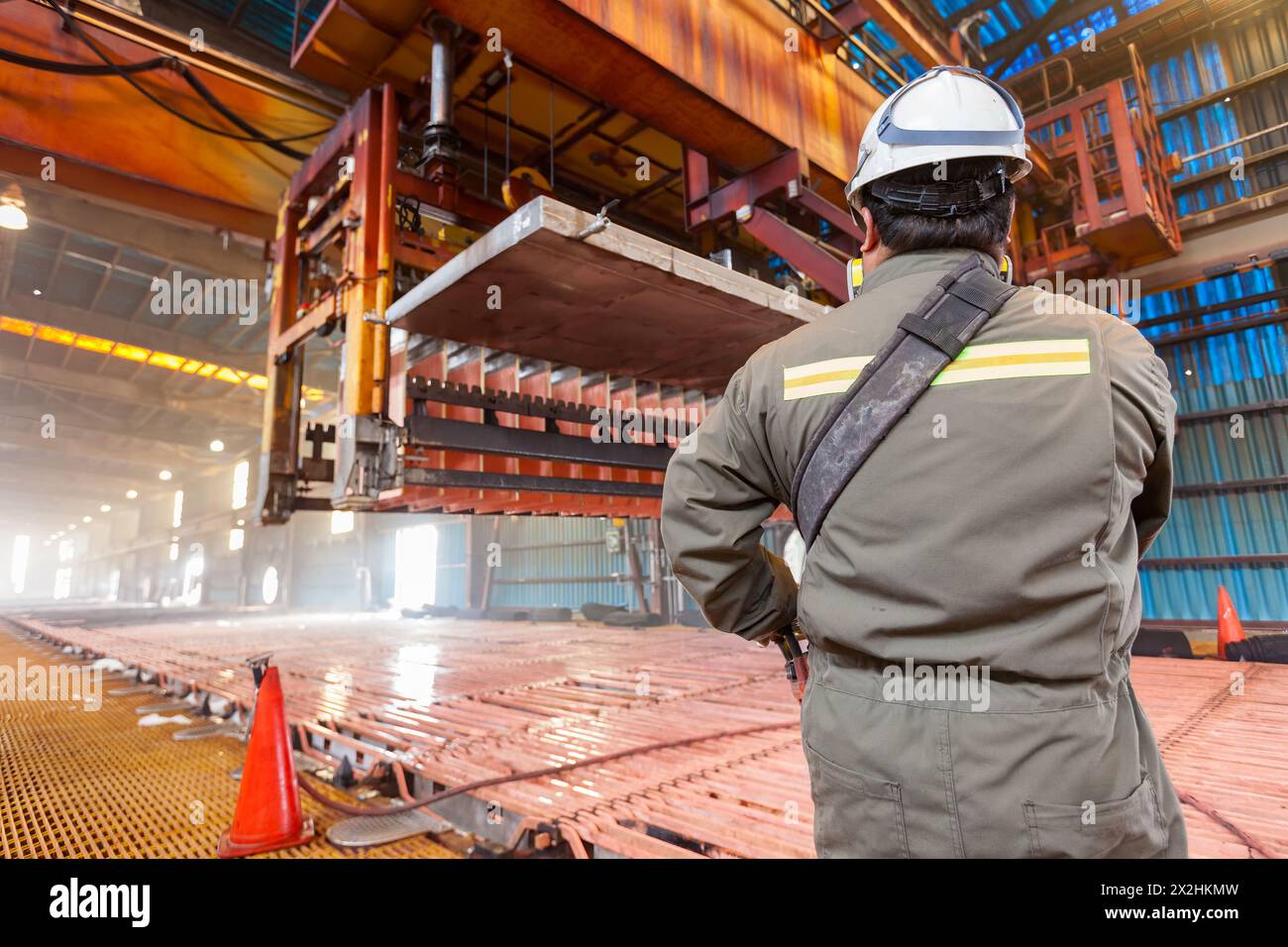 Worker controlling the crane that transports the copper cathodes at an ...
