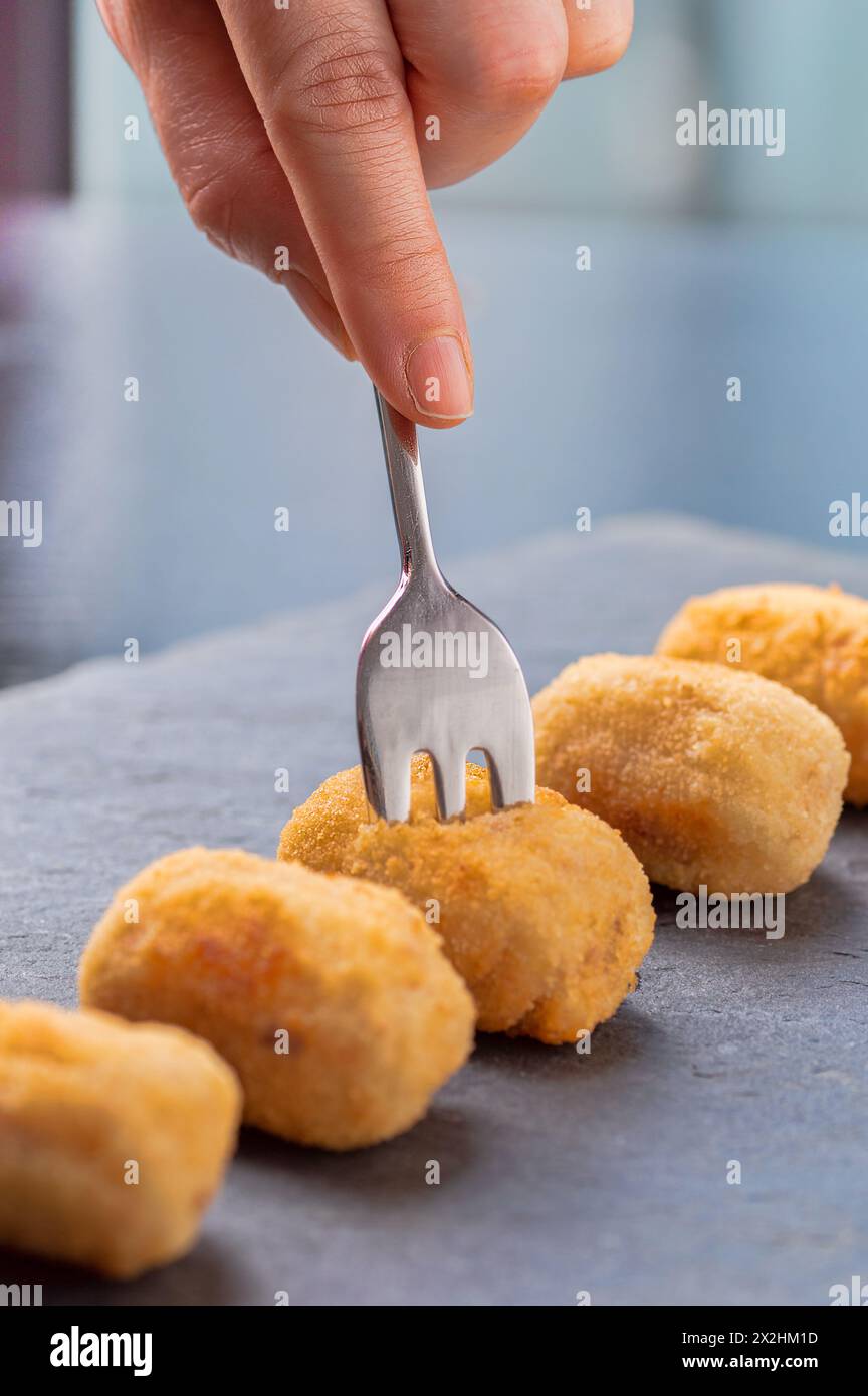 Close up of picking up homemade croquette with a fork, a typical ...