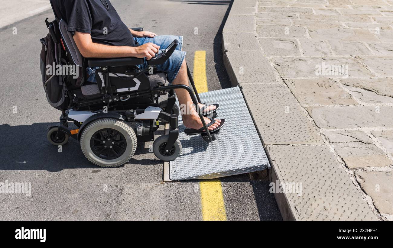Male tourist on wheelchair crossing over the threshold ramp on the ...
