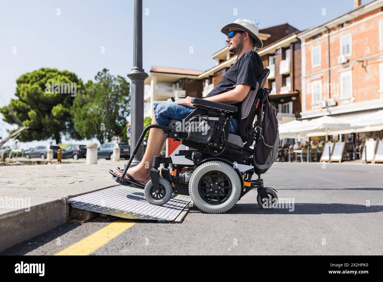 Male tourist on wheelchair crossing over the threshold ramp on the ...