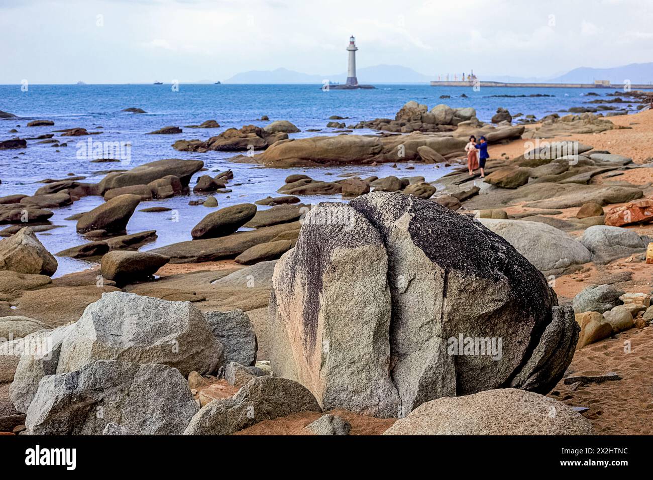 View of the lighthouse in the sea near the rocky shore. Heavenly ...