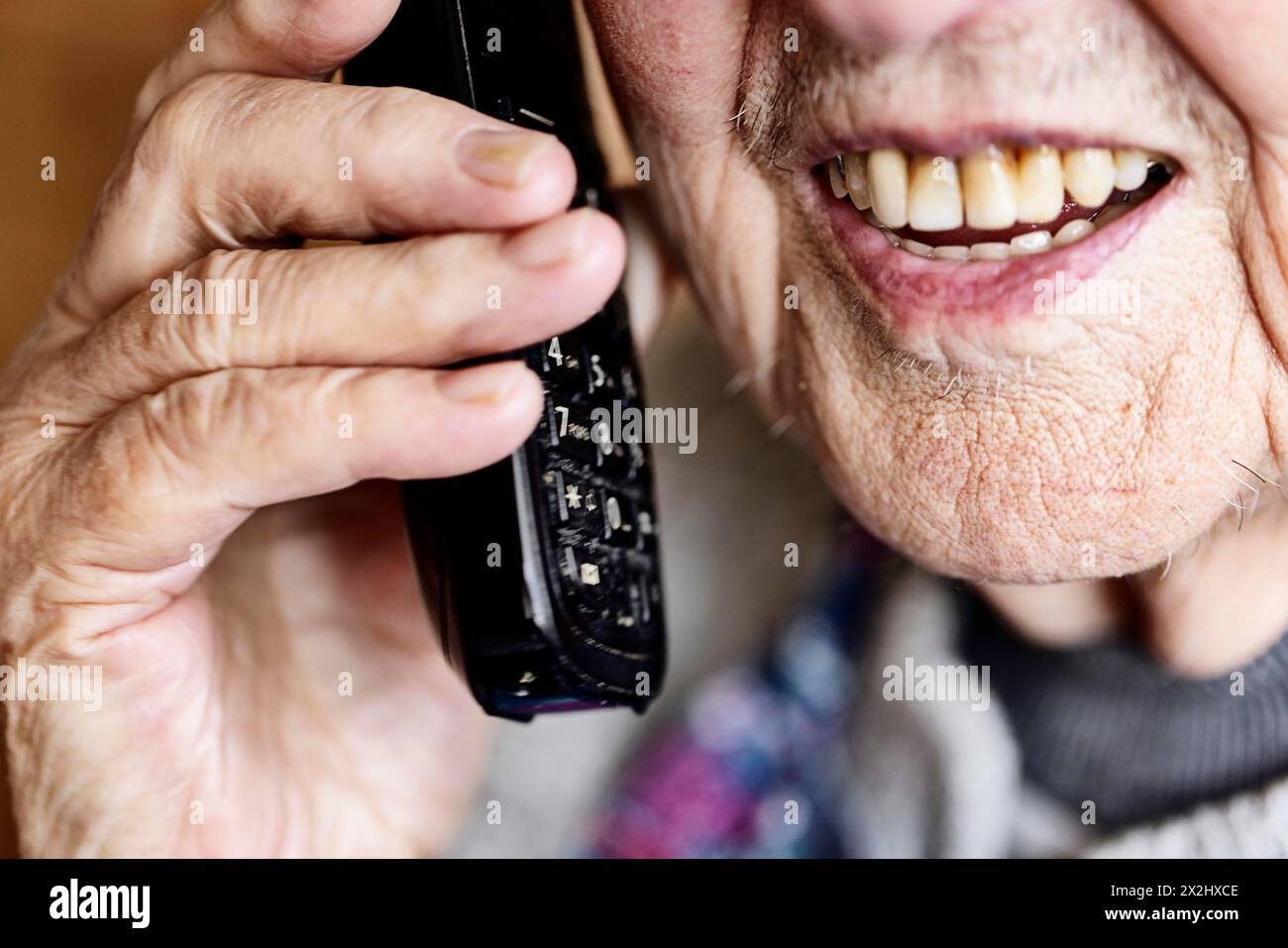 Mouth, hands and telephone receiver of a senior citizen making a phone ...