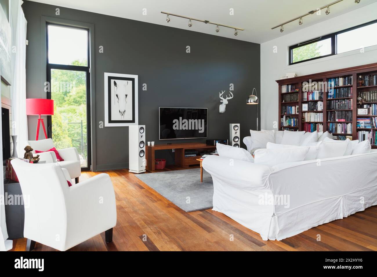 Living room with Qumaru wood floorboards, white leather armchairs, sofas, home entertainment ...