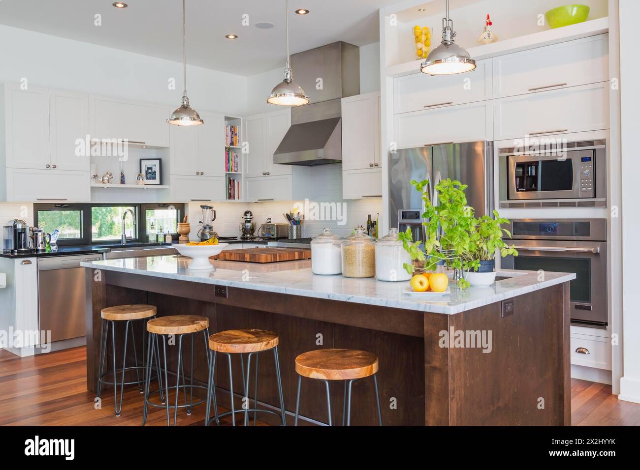 Kitchen area with white cabinets, marble top wooden island with painted ...