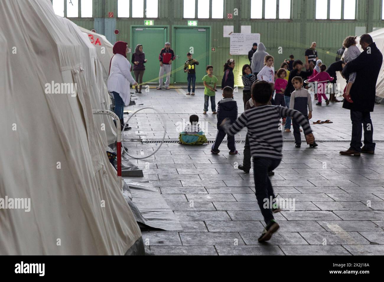 Children of refugees playing between tents in an emergency shelter for ...