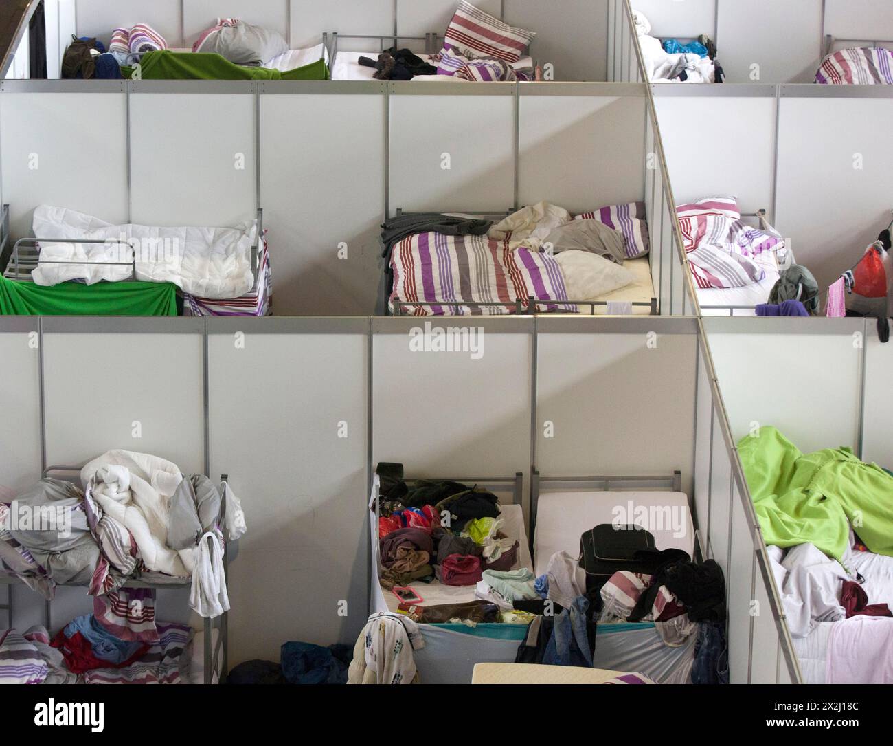 Temporary rooms with beds are set up in an emergency shelter for ...