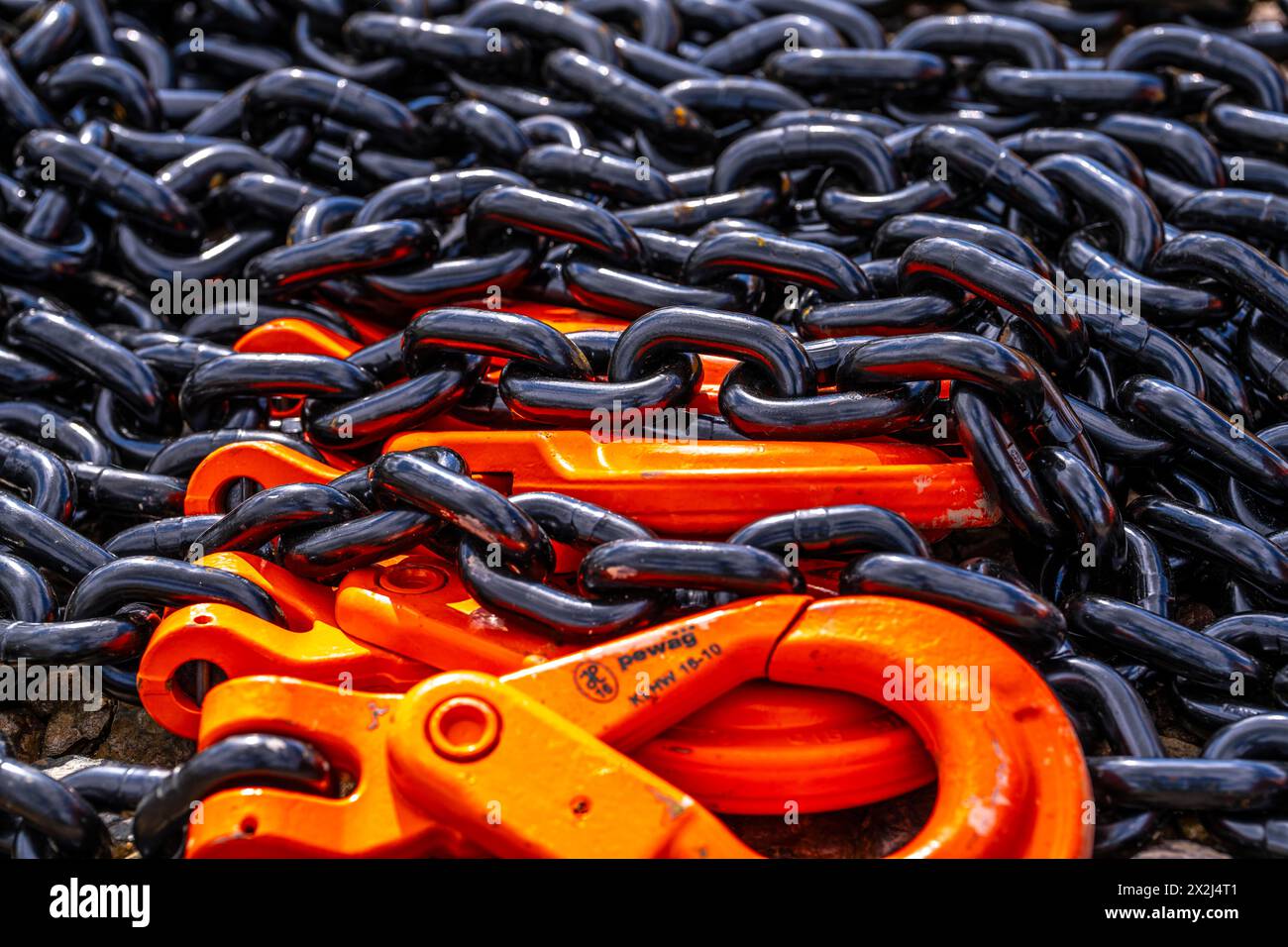 Heavy, thick chains made of steel, black chain links, orange painted ...