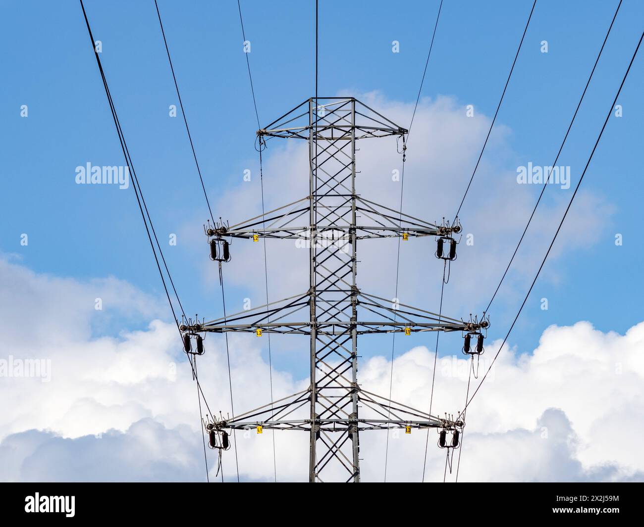 A high-voltage transmission pole with visible wires and insulators ...