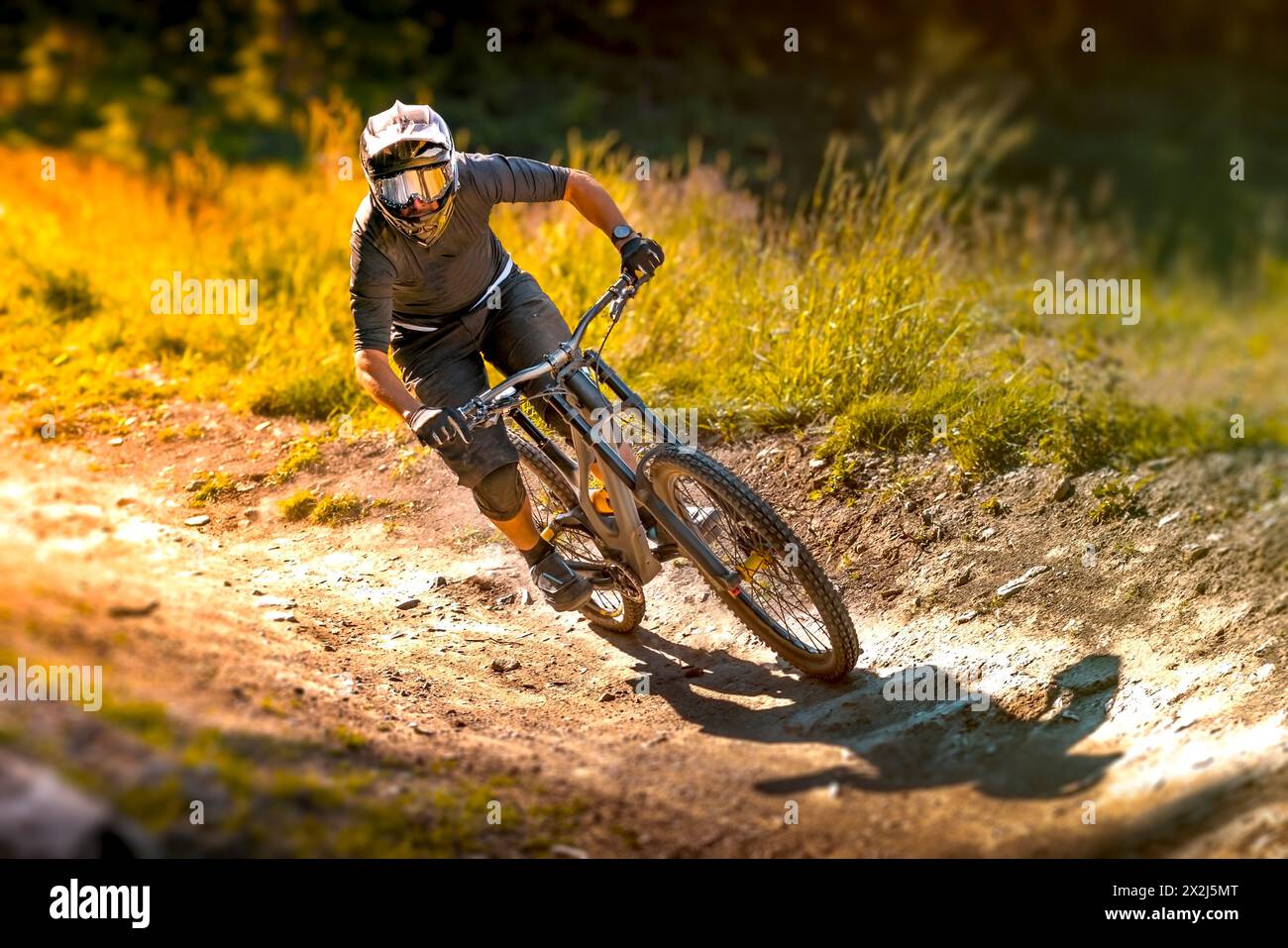 Downhill mountain biker in equipment going fast in the bike park trail ...