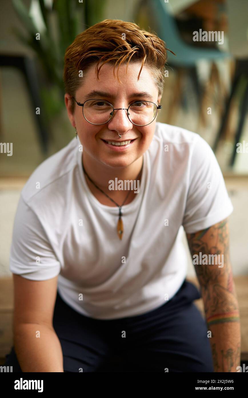 Positive Gen Z transgender person smiles in coworking space. Confident ...