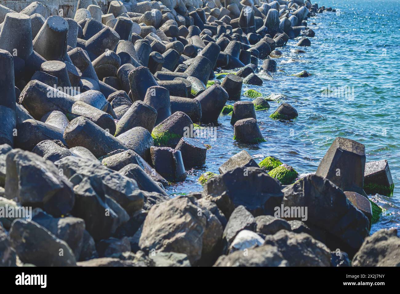Breakwater in sea. Coastal defense barrier made of concrete tetrapod ...