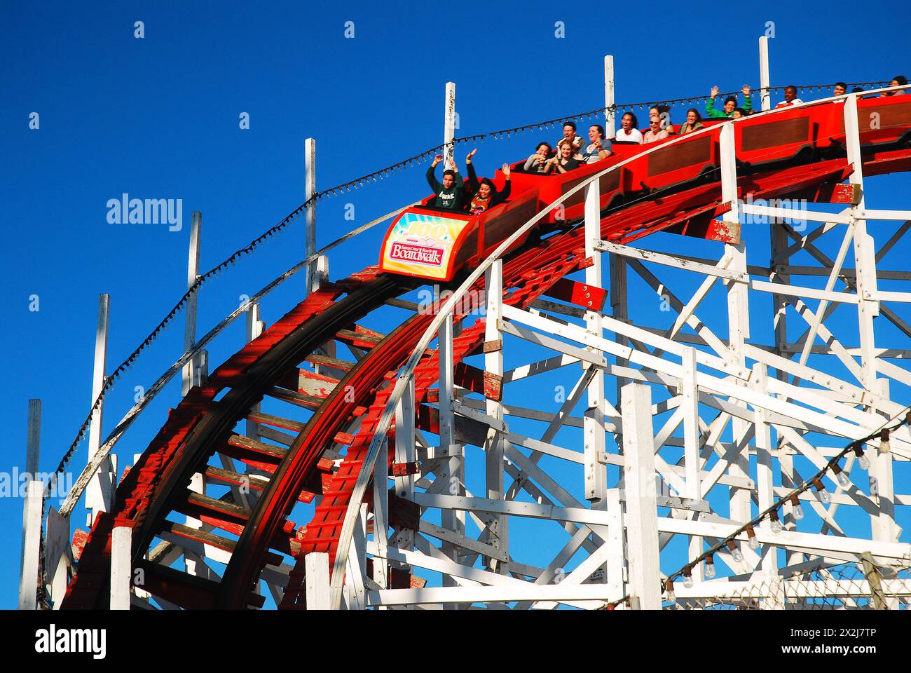 Riders raise their hands as they enter a descent on a historic wooden ...