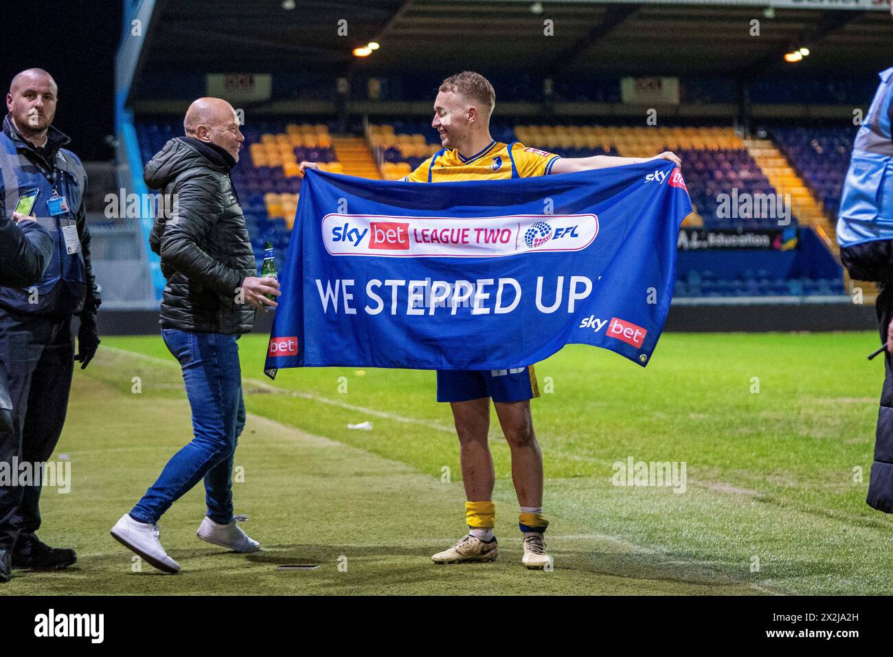 Mansfield Town FC midfielder Louis Reed (25) with a promotion banner ...