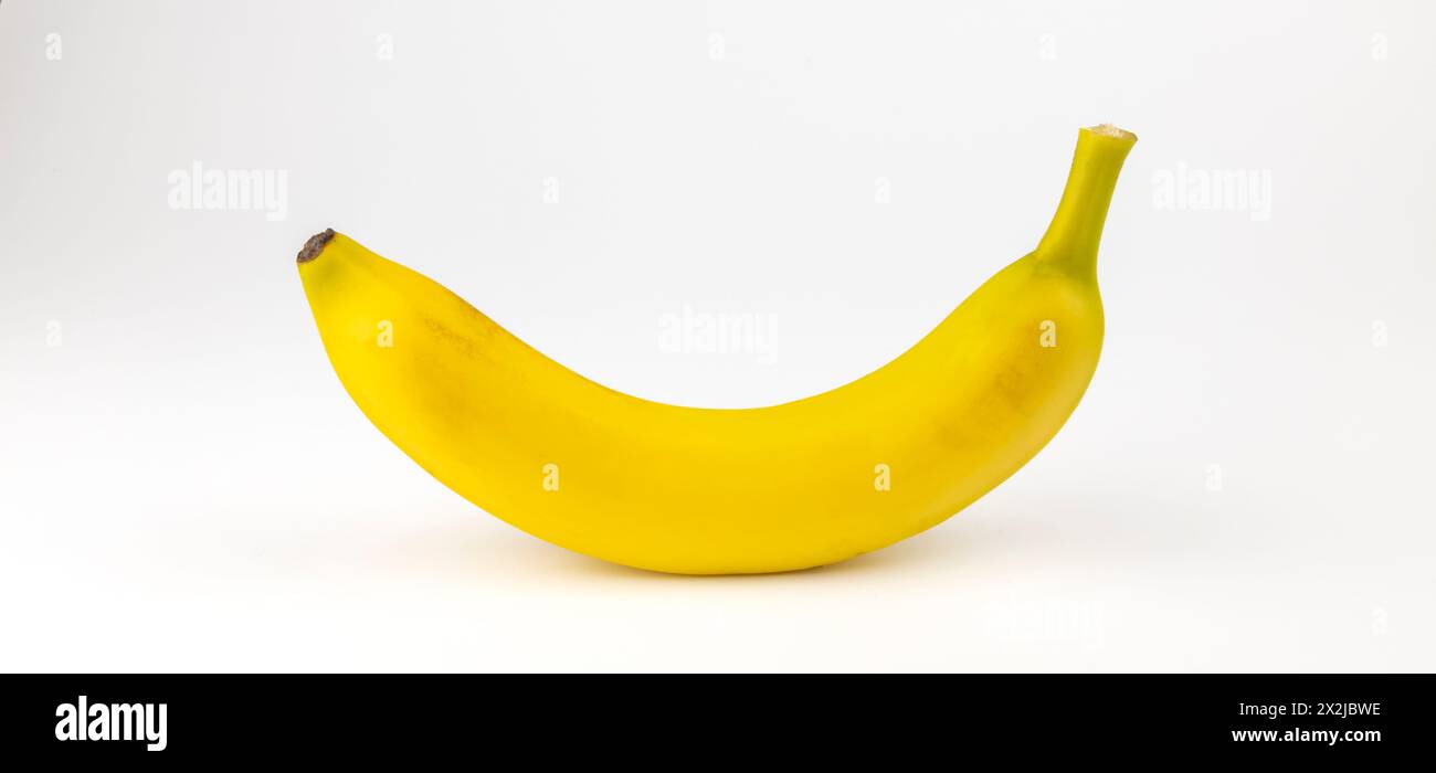 One yellow banana on a white background. The concept of taking vitamins ...