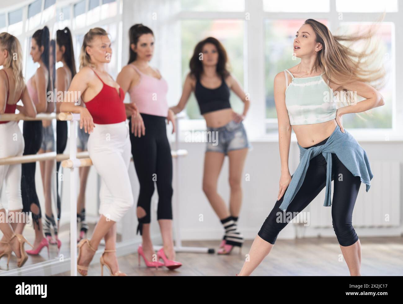Woman demonstrating movements of vogue dance during group class in studio Stock Photo - Alamy