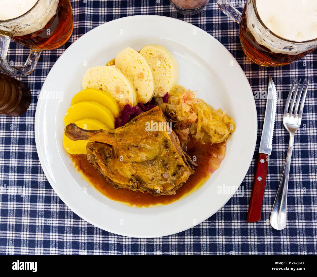 Roasted quarter duck with red and white cabbage, bread and potato ...