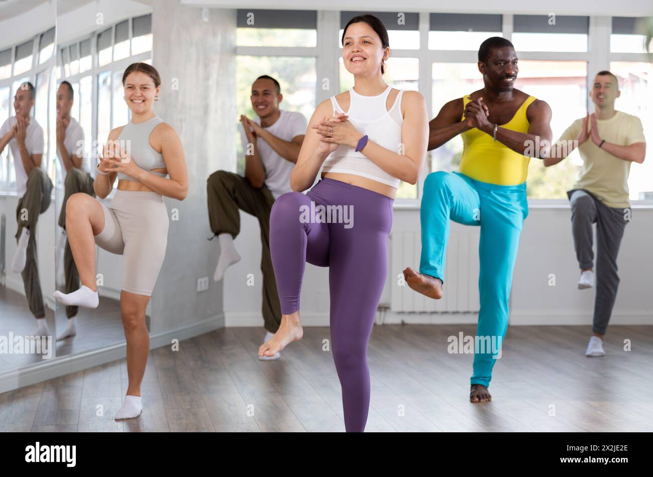 Happy girl and group of multinational young people practicing new ...