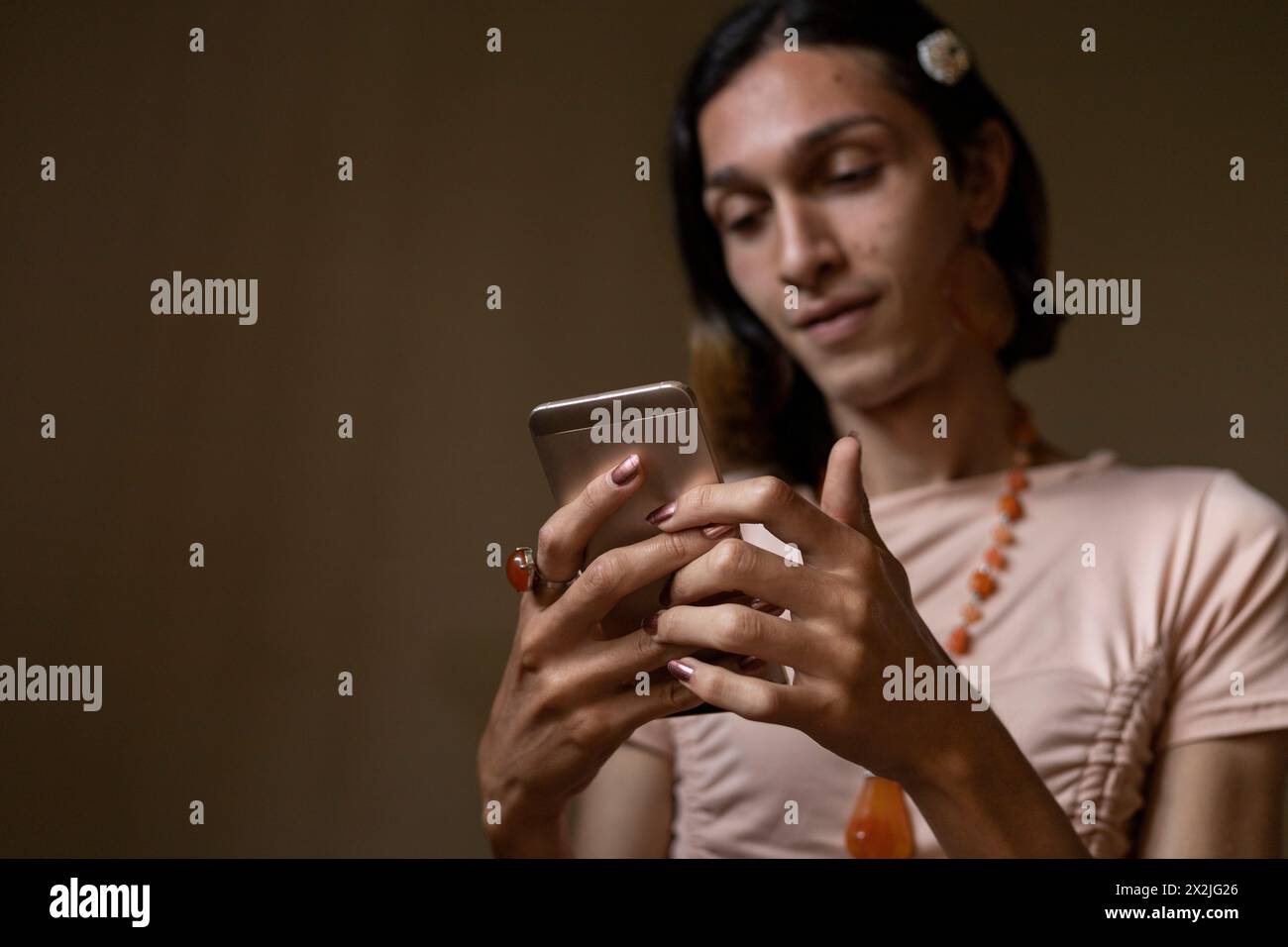 A young transgender man (22) is in his room typing a message from his ...
