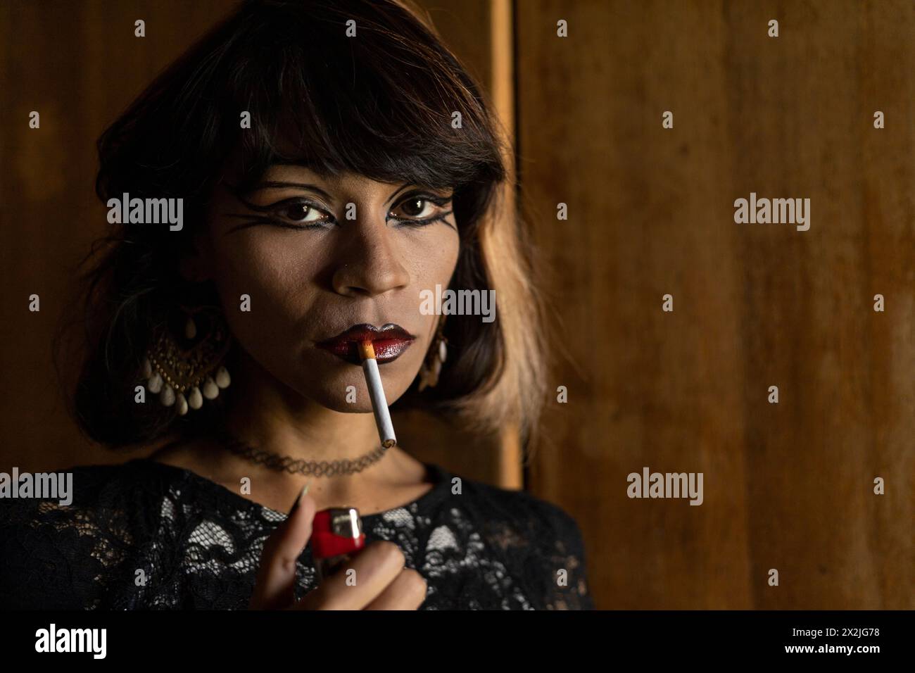 A young transgender man (26) is in his room with a cigarette in his ...