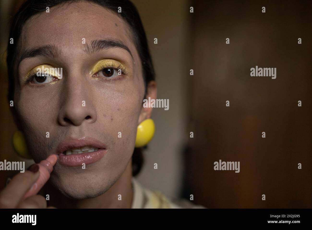 Young transgender man (22) is in his room applying makeup. Transgender ...