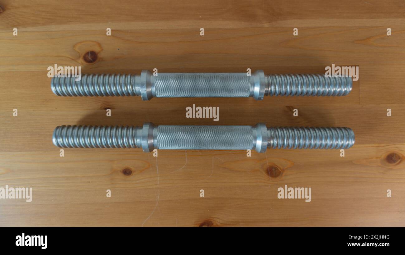 Parallel dumbbells on wooden texture, gym-ready Stock Photo - Alamy