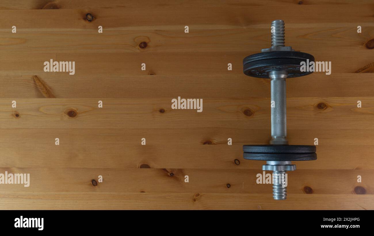 Dumbbell on wood, symbolizing strength training Stock Photo - Alamy