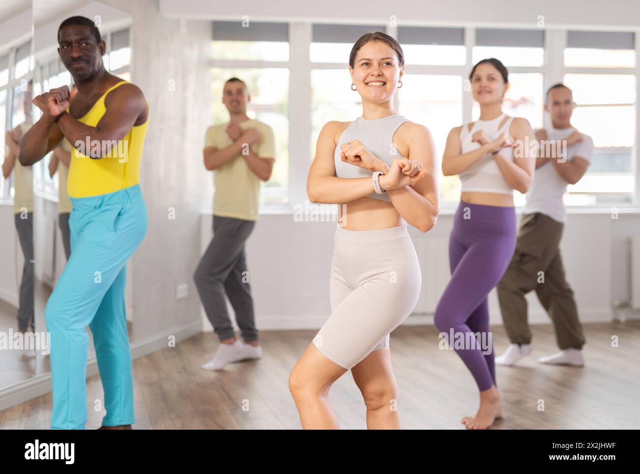 Young female fitness instructor leading upbeat Zumba class Stock Photo ...