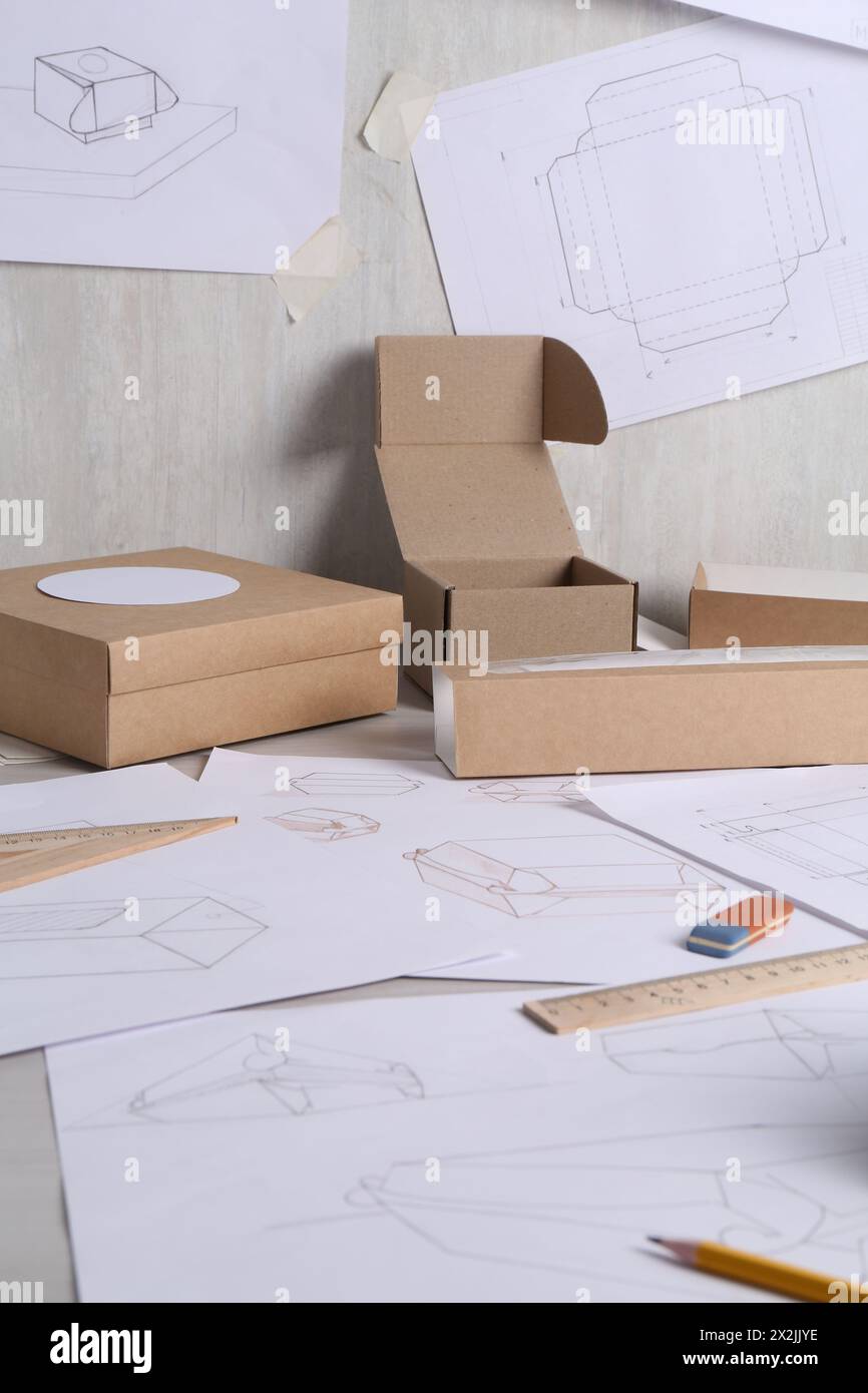 Creating packaging design. Drawings, boxes and stationery on light ...