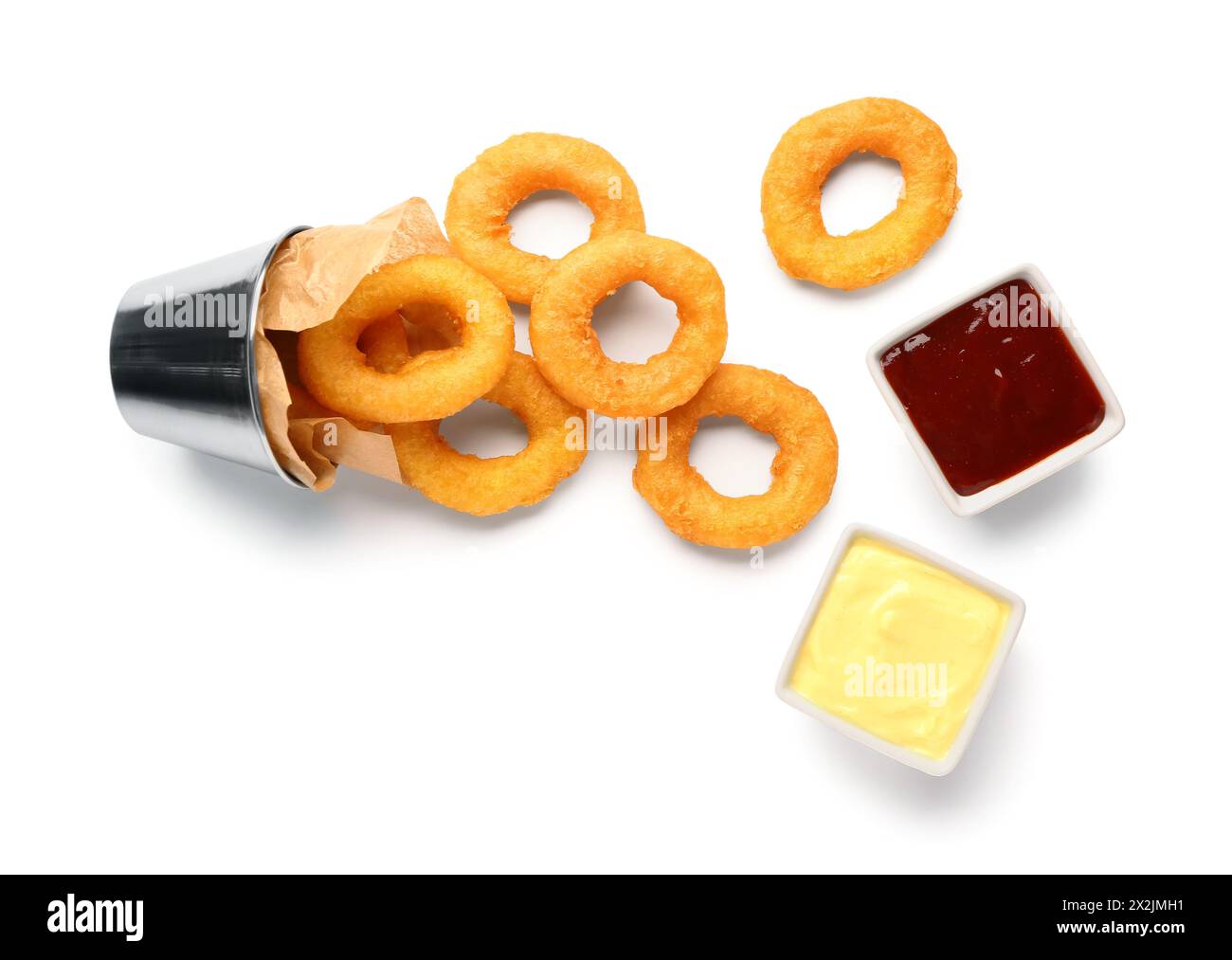 Metal bucket with fried breaded onion rings and different sauces on ...