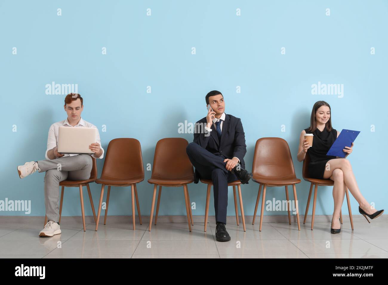 Applicants waiting for job interview near blue wall Stock Photo - Alamy