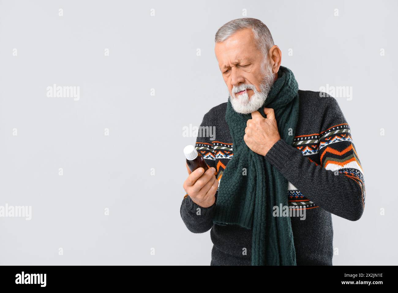 Old man with sore throat holding cough syrup on white background Stock ...