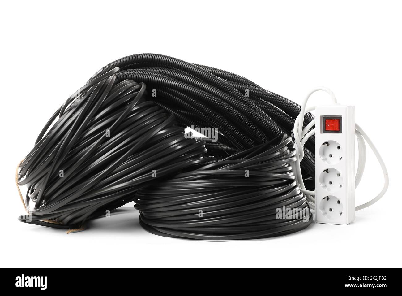 Rolled cables, flexible conduit tube and extension cord on white ...