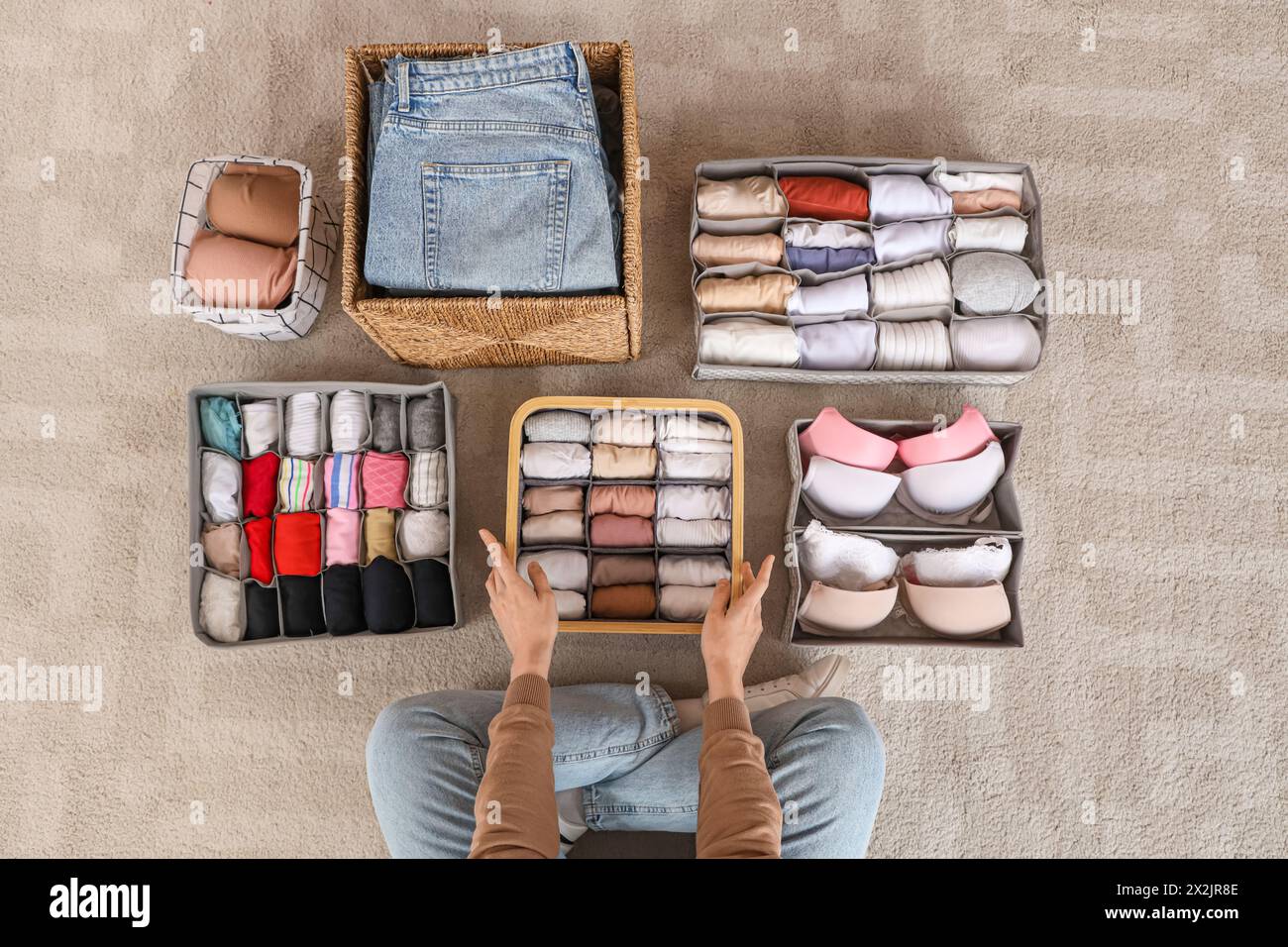 Beautiful young woman with clean clothes in different organizers at ...
