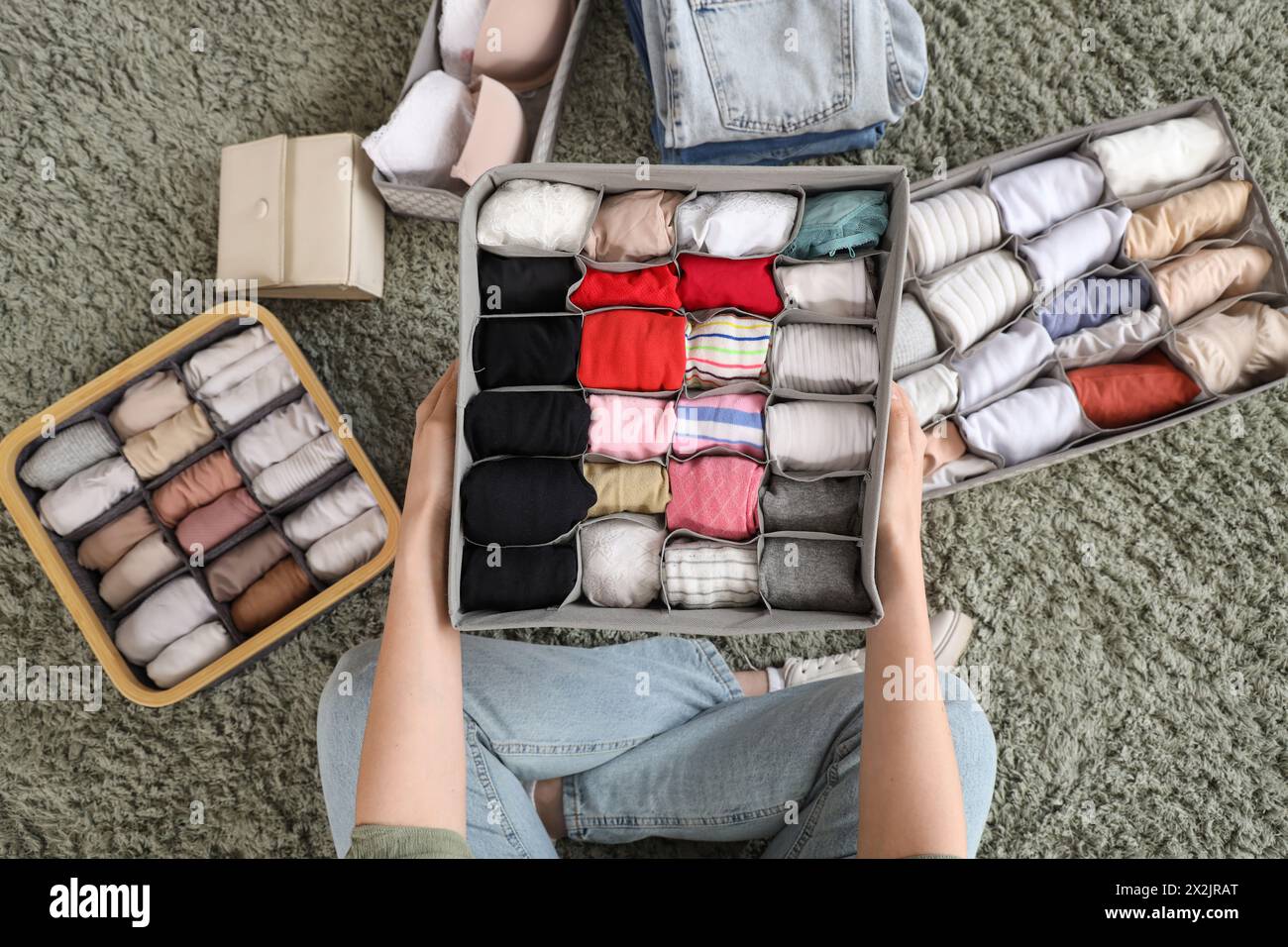 Beautiful young woman with clean clothes in organizers at wardrobe, top ...