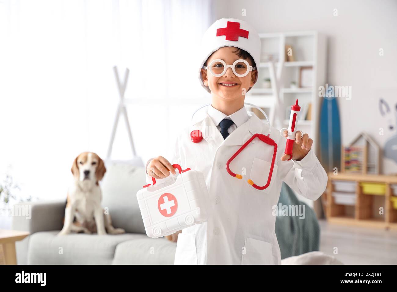 Cute little doctor with first aid kit and toy syringe at home Stock ...